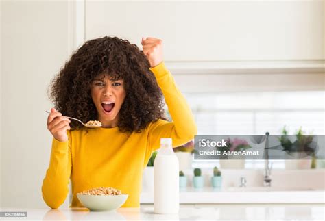 시리얼과 우유를 집에서 먹는 아프리카계 미국인 여자 화가 좌절 분노 미친 제기 손으로 소리를 외치는 분노 개념 감정에 대한 스톡 사진 및 기타 이미지 Istock