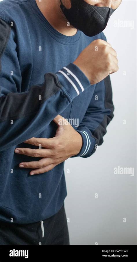 Someone Wearing A Mouth Mask Who Is Coughing And Holding His Chest