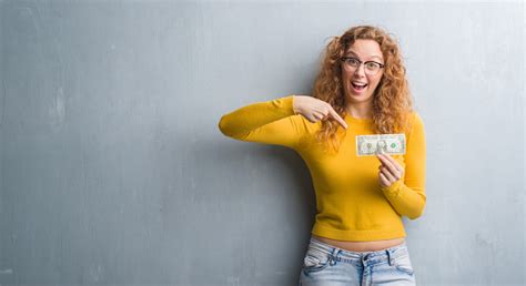 손과 손가락으로 가리키는 매우 행복 달러를 들고 회색 그런 지 벽에 빨강 머리 젊은 여자 가리키기에 대한 스톡 사진 및 기타 이미지 가리키기 감정 곱슬 머리 Istock
