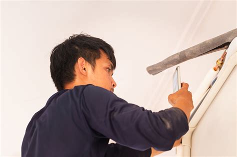 에어컨 기술자는 가정에 새 에어컨을 설치하고 수리공은 에어컨 시스템을 수리하고 남성 기술자는 에어컨 수리 및 유지 보수를 위해