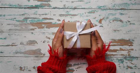 위의 보기 빨간 스웨터를 입은 여자는 나무 배경에 선물 상자를 들고 있다 사진 Unsplash의 성인 전용 이미지