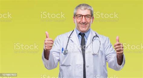 격리 된 배경 성공 기호 손으로 긍정적인 제스처를 하 고 웃 고 행복 한 엄지손가락에 잘생긴 수석 의사 남자 쾌활 한 식 우승자 제스처와 카메라를 보면 건강관리와 의술에