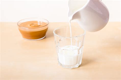 달곤에서 커피를 만드는 방법 단계별 사진 지시 5단계 우유를 유리에 붓습니다 재료 인스턴트 커피 설탕 물 우유 및 나무 배경에