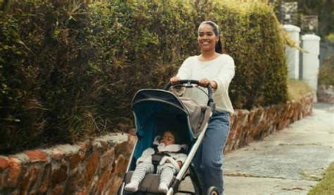 자연 유모차 및 엄마는 신선한 공기 유대감 및 양질의 가족 시간을 야외에서 즐기는 아기와 함께 걷고 있습니다 런던에서 아이 아이 또는 신생아와 함께 이웃 거리에서 미소 사랑