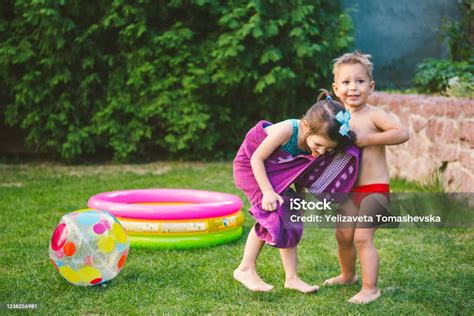 여름 방학 동안 비치 타월에 싸여있는 아이들 수건여름 수영장에서 젖은 아이들 여름 분지에서 행복한 시간을 보내는 아기 집에서