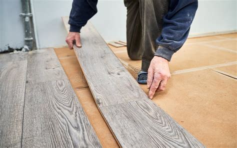 Male Worker Hands Laying Laminate Flooring In Apartment Stock Image