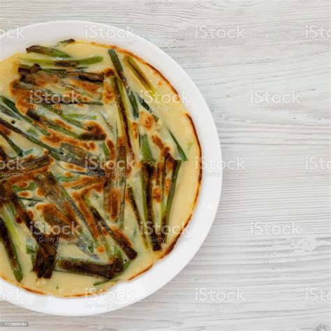 수제 한국산 파전 파전 스캘리온 팬케이크는 흰색 나무 표면에 흰색 접시에 꼭대기 보기 아시아 음식 플랫 레이 오버 헤드 오버 헤드 공간을 복사합니다 건강한 생활방식에 대한