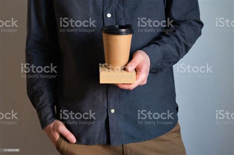 남자는 커피 나 차와 함께 손 종이 컵에 들고 사업가가 커피를 마십니다 순간을 즐기고 휴식을 취하십시오 커피가서 일회용 종이 컵 카페에서 서비스를 가져 가라 뜨거운 맛있는