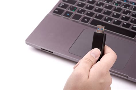 한 여성이 손에 검은 색 Usb 플래시 드라이브를 들고 있다 흐린 배경에 검은 색 키보드가있는 실버 노트북 흰색 배경에 격리 Usb 메모리에 대한 스톡 사진 및 기타 이미지