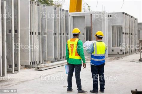 뒤 Viewconstruction 청사진 종이 아시아계 인도 건설 건축가 엔지니어링 남자와 안전 안전모의 선임 노동자는 조립식 콘크리트 공장에서 청사진 작업을 하고 있다