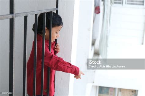흰색 도시 배경의 발코니에 서있는 동안 활기찬 빨간 셔츠를 입고 인도 귀여운 작은 쾌활한 갈색 머리 타밀 아기 소년의 초상화 2 3 살에 대한 스톡 사진 및 기타 이미지