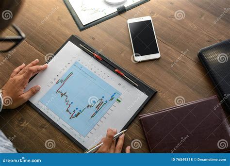 Business Woman At Workplace At Wooden Office Table Analyzes The Data Schedules Prices Makes