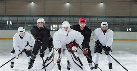 장갑 스케이트 헬멧을 쓴 프로 하키 선수들이 경기장에서 경기하기 전에 훈련 중 아이스링크에 서서 앞으로 구부리고 있습니다 사진 Unsplash의 하키 이미지