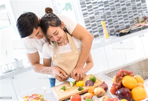 젊은 아시아 남자와 여 자가 함께 절단 조각 야채 부엌 방 및 홈 로맨틱 실내 달콤한 각 샐러드와 과일로 저녁 식사 메뉴에 대