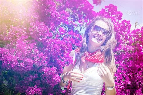 女孩在阳光下的花背景上笑