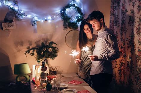 집에서 새해 전야를 축하하는 불타는 스파클러 벵골 빛을 들고 세련된 커플 메리 크리스마스 개념 함께 겨울 휴가를 축하 불꽃 놀이와 행복한 가족 동유럽 후예에 대한 스톡 사진