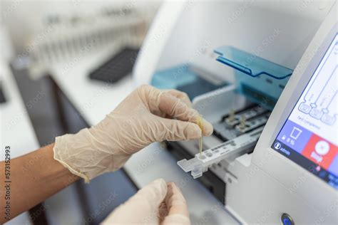 Female Laboratory Assistant Making Analysis With Test Tubes And Analyzer Machines Sitting At The