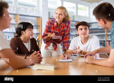 Classmates Have Fun Chatting And Telling Each Other In School Library