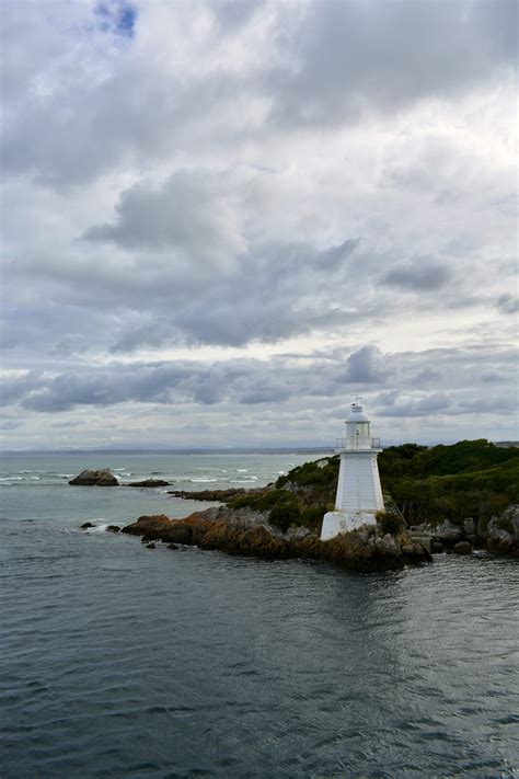 A Lighthouse On An Island In The Middle Of The Ocean Photo Free