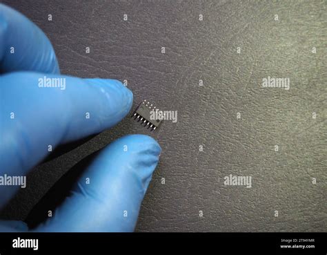 Semiconductor Industry Hand Holding An Electronic Micro Chip 14 Pins Surface Mount Technolgy
