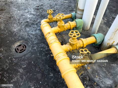 산업용 유체 흐름 제어를 위한 노란색 배관 밸브의 클로즈업 산업용 파이프라인 시스템이 있는 옥상 물 저장 탱크 0명에 대한 스톡