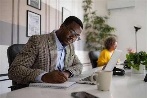 사무실에서 노트북으로 작업하면서 메모를 하는 흑인 사업가 25 29세에 대한 스톡 사진 및 기타 이미지 25 29세 2명 55 59세 Istock