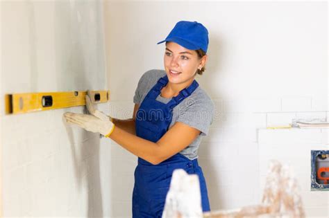 Young Woman Worker Uses A Spirit Level On The Bathroom Wall Stock Image Image Of Female Level