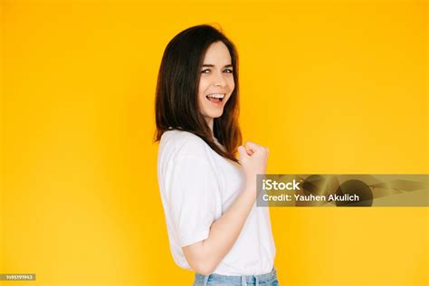 승리의 제스처 주먹을 들고 흥분하여 외치는 열정적인 여성 노란색 배경에 성공 성취 및 긍정적인 에너지를 포착 여자에 대한 스톡 사진 및 기타 이미지 Istock