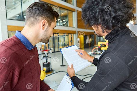 Engineers Discussing Robotics And Automation Solutions In A Modern Office Setting Stock Image