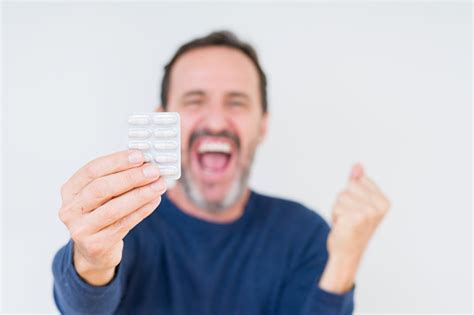 수석 남자 자랑 비명과 축 하 하는 승리와 성공을 매우 흥분된 하 고 격리 된 배경 위에 제약 알 약을 들고 환호 하는 감정