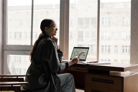 Premium Photo A Female Programmer Works In An Office Uses A Laptop
