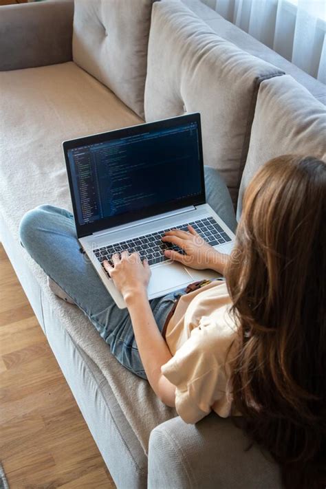 Woman Working On A Laptop While Sitting On The Sofa A Girl Programmer