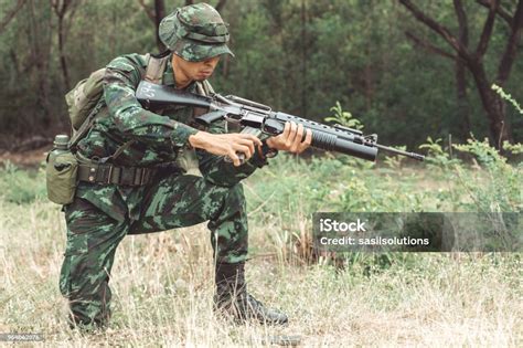 군인 그의 소총을 로드 해입니다 그의 무기를 다시 로드 하 고 그의 총 안에 그의 Magzine 중국 전문 군인 아래로 작업 Kneeing 개성 개념에 대한 스톡 사진 및