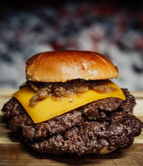 Smashed Cheeseburger On A Wooden Table In Front Of A Fireplace Stock