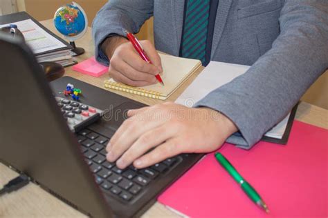 Man Writing Notes From Computer On Wooden Table Man Hand With Pen Calculator And Computer On