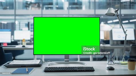 현대 비즈니스 오피스의 책상 위에 서 있는 모의 녹색 화면 크로마 키 디스플레이가 있는 데스크탑 컴퓨터 모니터 큰 도시 사무실배경 유리 벽에 컴퓨터 모니터에 대한 스톡 사진