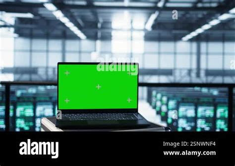 Green Screen Laptop In Front Of Data Center Engineers In Blurry Background Calibrating Energy