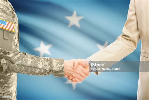 옷을 입은 미국 군인과 양복을 입은 시민이 배경에 국기로 악수 미크로네시아 계약서에 대한 스톡 사진 및 기타 이미지 계약서 군복 군사 Istock