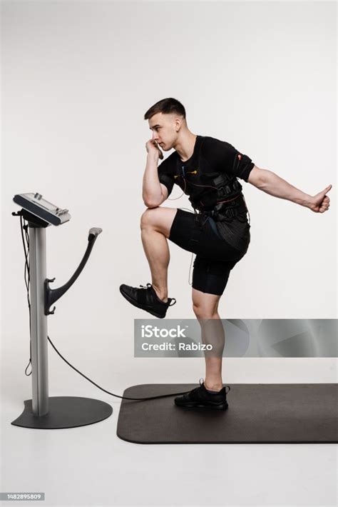 Ems 슈트를 입은 근육질의 남성 운동선수는 흰색 배경에 근육을 자극하기 위해 전기 충격을 사용하는 운동 스포츠 훈련을 하고 있다 전기 근육 자극 슈트에서 스포츠 훈련 20