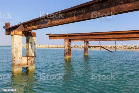 오래된 콘크리트 지지 구조물과 맑은 푸른 지중해 물에 서 녹슨 금속 빔은 파마구스타 북부 키프로스 근처의 오래된 부두의 남아있는