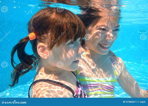 Les Filles Heureuses Nagent Sous L Eau Dans La Piscine Image Stock