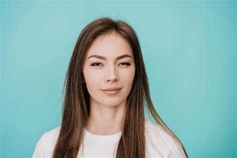 건강한 피부를 가진 자신감있는 백인 여성의 초상화를 클로즈업하고 청록색 스튜디오 배경 위에 카메라를 바라 봅니다 흰색 티셔츠 모형 아름다움 및 건강 관리에 스웨덴의 젊은