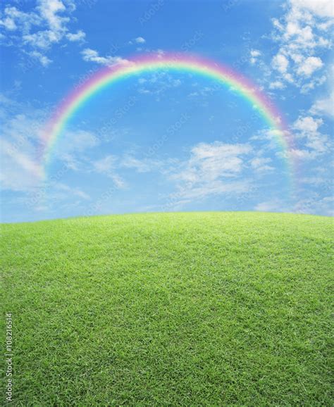 Rainbow With Green Grass Field Over Blue Sky Nature Background Stock