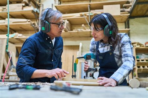 Experienced Craftsman Mentoring Apprentice In Busy Lumberyard Workshop Stock Image Image Of