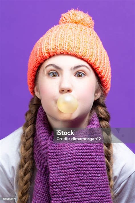 보라색 매끄러운 배경에 대한 얼굴 앞에서 껌 거품을 츄잉 껌 거품 포즈 산호 니트 계절 모자에 재미 윈섬 소녀 14 15 살에 대한 스톡 사진 및 기타 이미지 Istock
