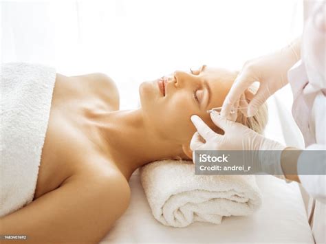 미용사 의사는 햇볕이 잘 드는 클리닉에서 주사기로 여성의 얼굴에 미용 절차를 수행합니다 성형 의학 및 수술 미용 주사 개념 25