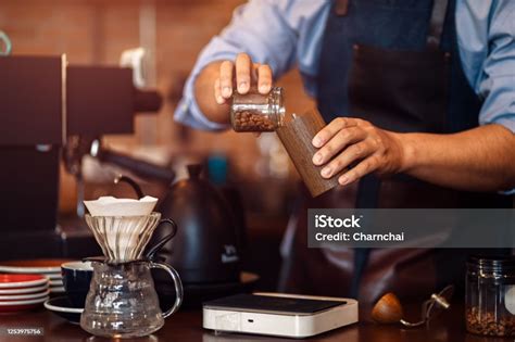 바리스타는 카페에서 커피 콩을 분쇄하기 위한 수동 분쇄기 커피를 손에 쥐고 있습니다 끓음에 대한 스톡 사진 및 기타 이미지 끓음 따르기 레스토랑 Istock