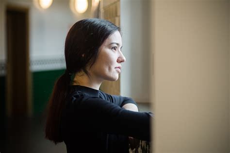 녹색 타일 복도에서 창 옆에 서 있는 검은 드레스 입은 혼합 인종의 젊은 아름 다운 모델의 실내 초상화 검은색에 대한 스톡 사진