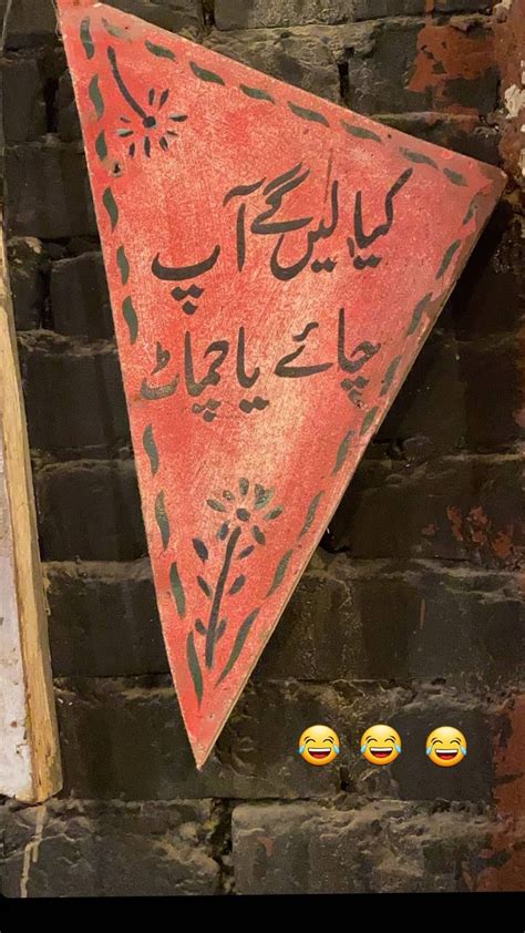 Red Triangular Sign Hanging On Brick Wall