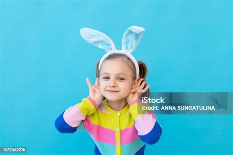 줄무늬 재킷에 토끼 귀를 가진 어린 소녀의 초상화미소와 탐닉 부활절 휴일의 개념 파란색 배경 사진 스튜디오 텍스트 장소 6 7 살에 대한 스톡 사진 및 기타 이미지 Istock